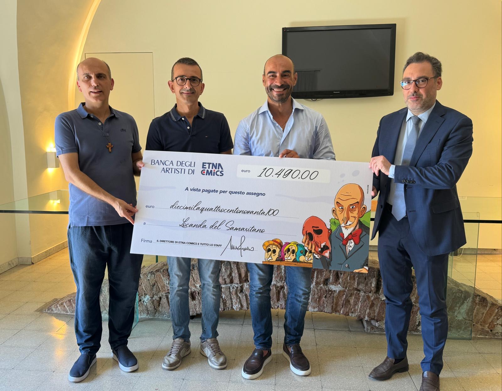 Etna Comics consegna alla Locanda del Samaritano un maxi assegno da 10. ...